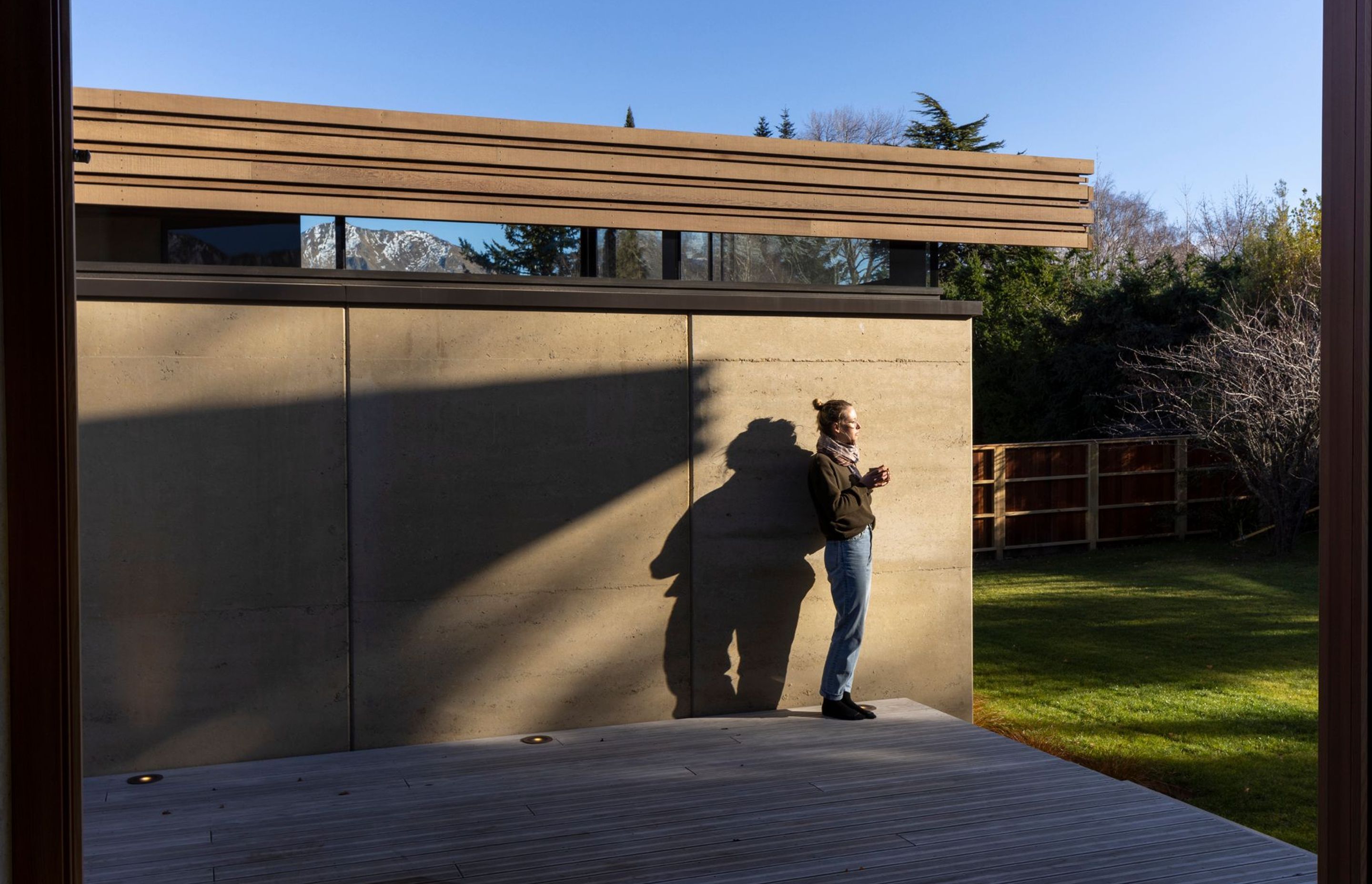 The rammed earth house with a curved roof that lifts toward the sun