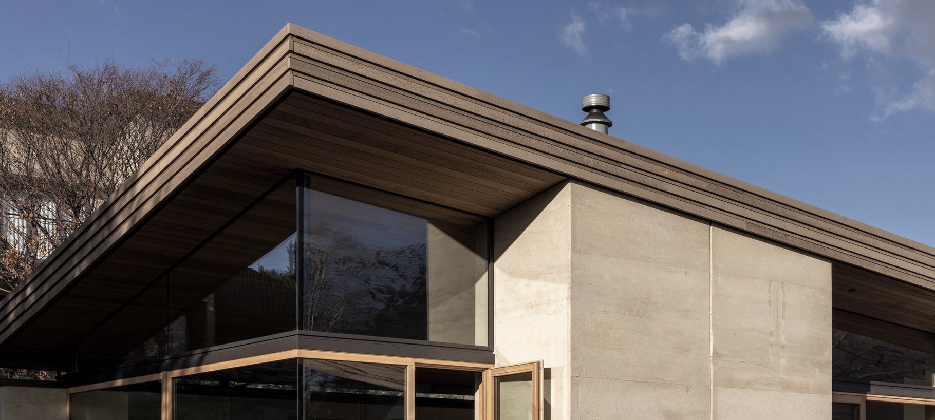 The rammed earth house with a curved roof that lifts toward the sun ...